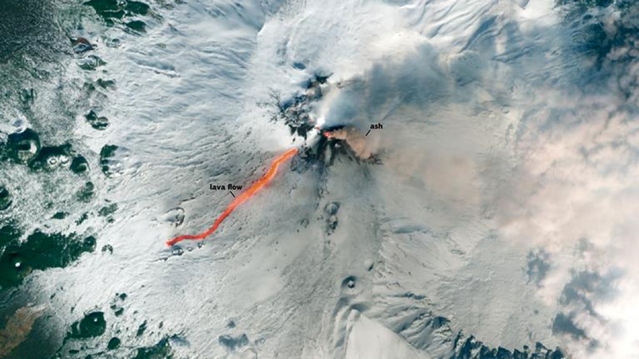 Erupcja wulkanu Etna. Strumień lawy widoczny z kosmosu na zaśnieżonym ...
